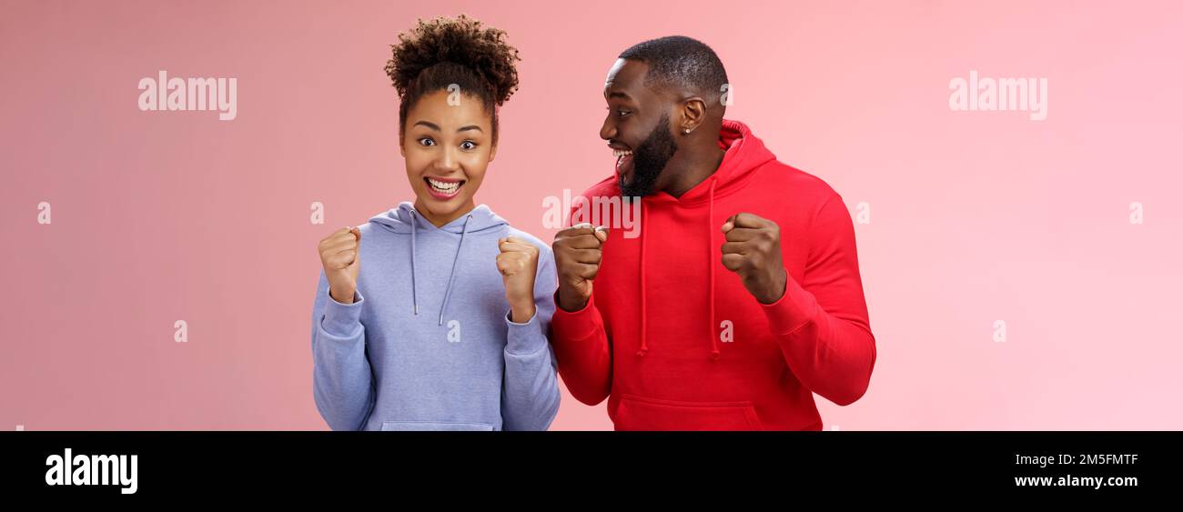 Happy enthusiastic thrilled young african american couple clenching ...