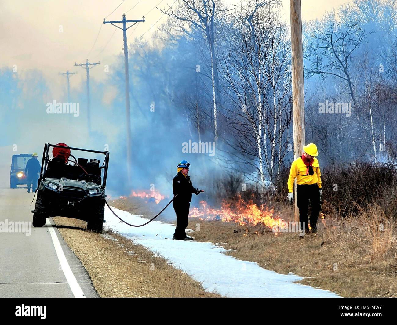 Team members oversee a prescribed burn March 14, 2022, along the ...