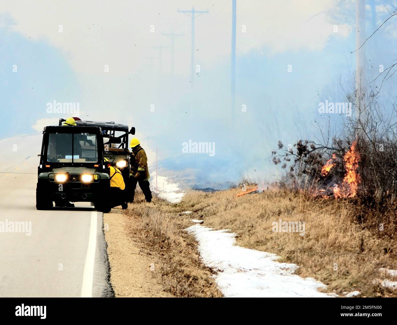 Team members oversee a prescribed burn March 14, 2022, along the ...