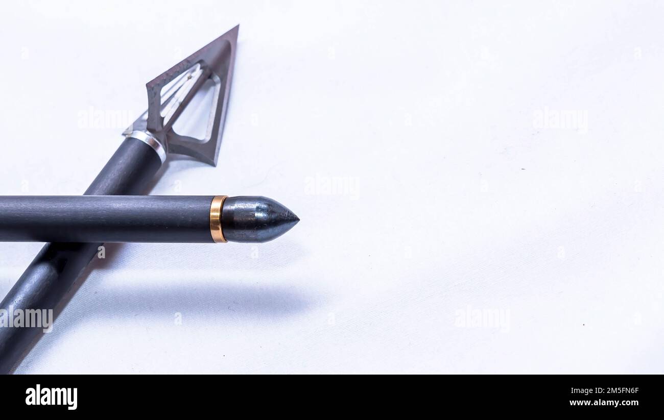 A three blade broadhead on the end of a carbon arrow and another with a ...