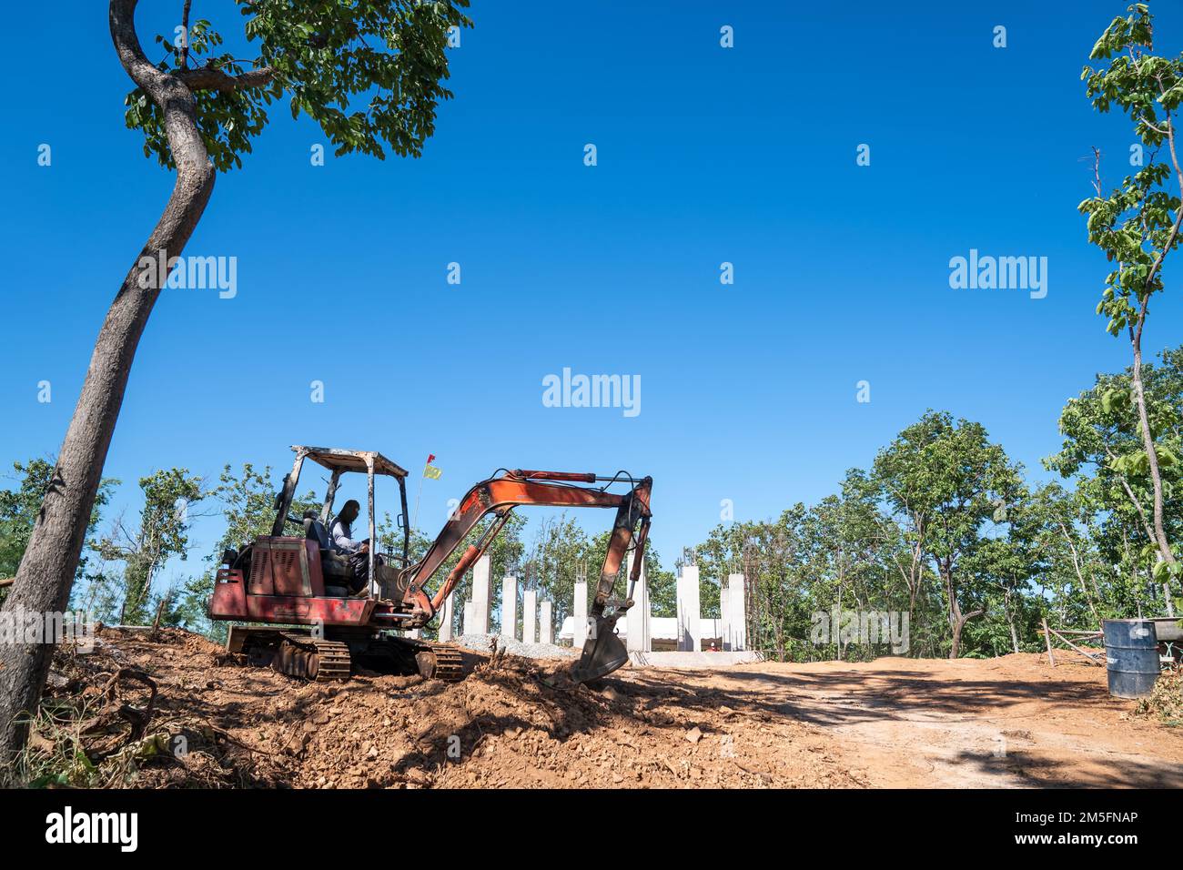 Hydraulic excavator is digging soil at a construction site, surrounded ...