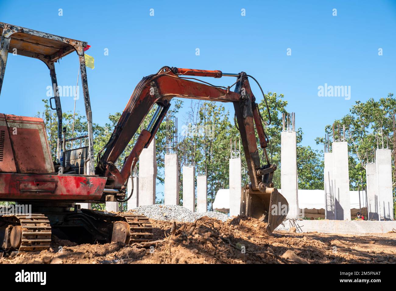 Hydraulic excavator is digging soil at a construction site, surrounded ...