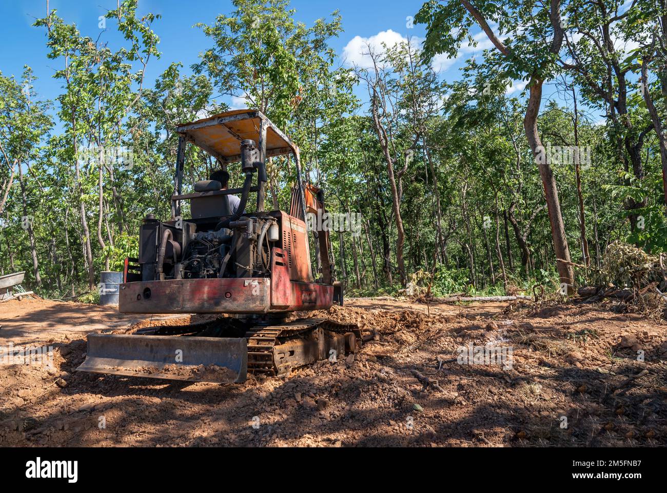 Hydraulic excavator is digging soil at a construction site, surrounded ...