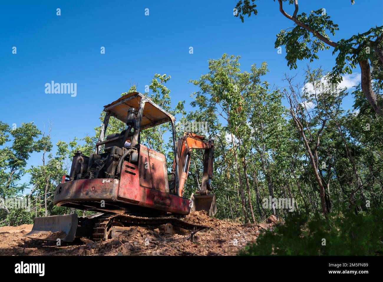 Hydraulic excavator is digging soil at a construction site, surrounded ...
