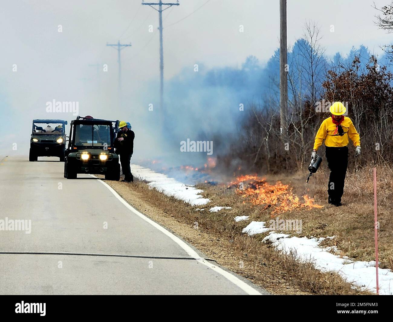 Team members oversee a prescribed burn March 14, 2022, along the ...