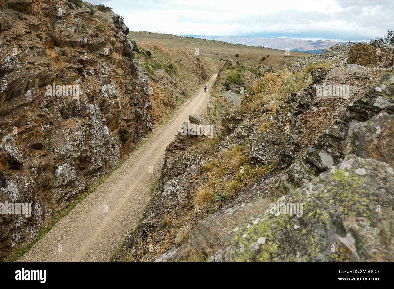 Dirt track through rock cutting on Central Otago Rail Trail in South ...