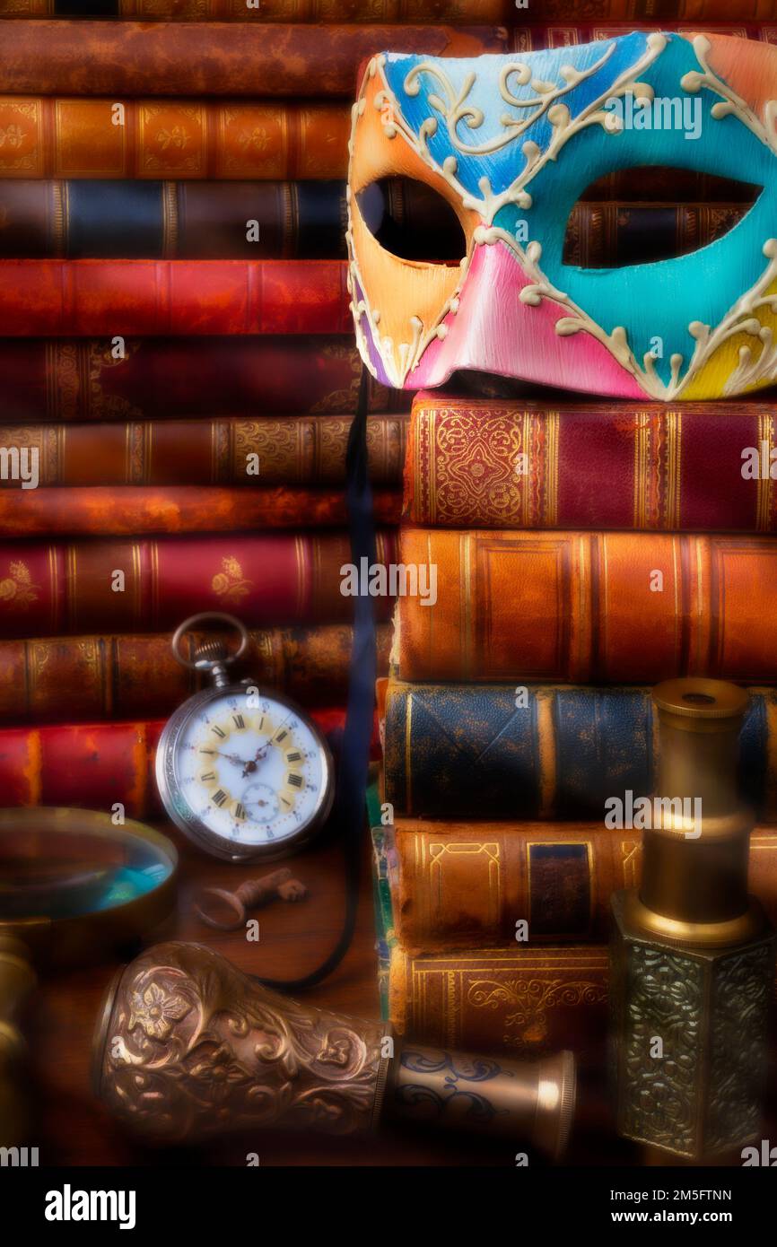 Old Mask On Stack Of Antique Books Stock Photo - Alamy