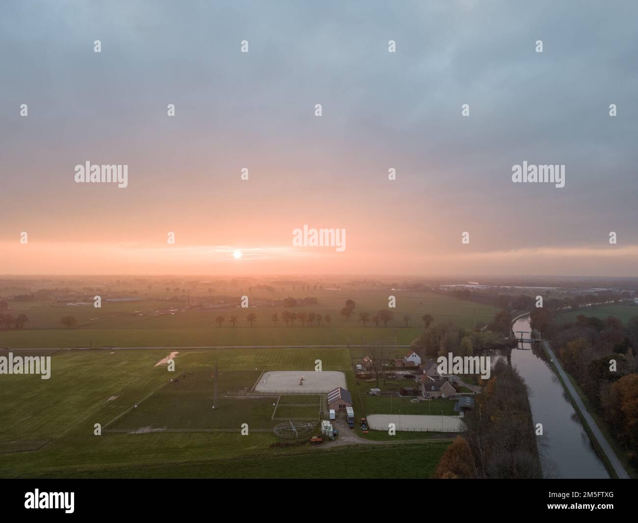 Beautiful sunset over a river with green bushes and color rich sky ...