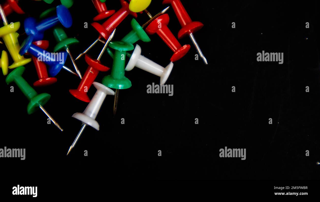 colorful thumbtacks on black background Stock Photo - Alamy
