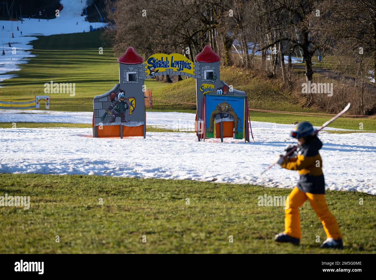 Lenggries, Germany. 28th Dec, 2022. A boy crosses a green meadow with ...