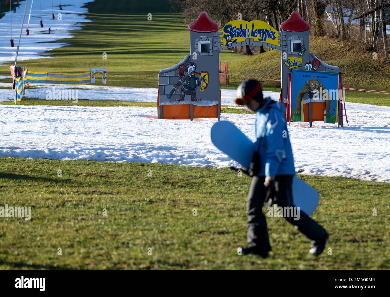 Lenggries, Germany. 28th Dec, 2022. A boy crosses a green meadow with ...