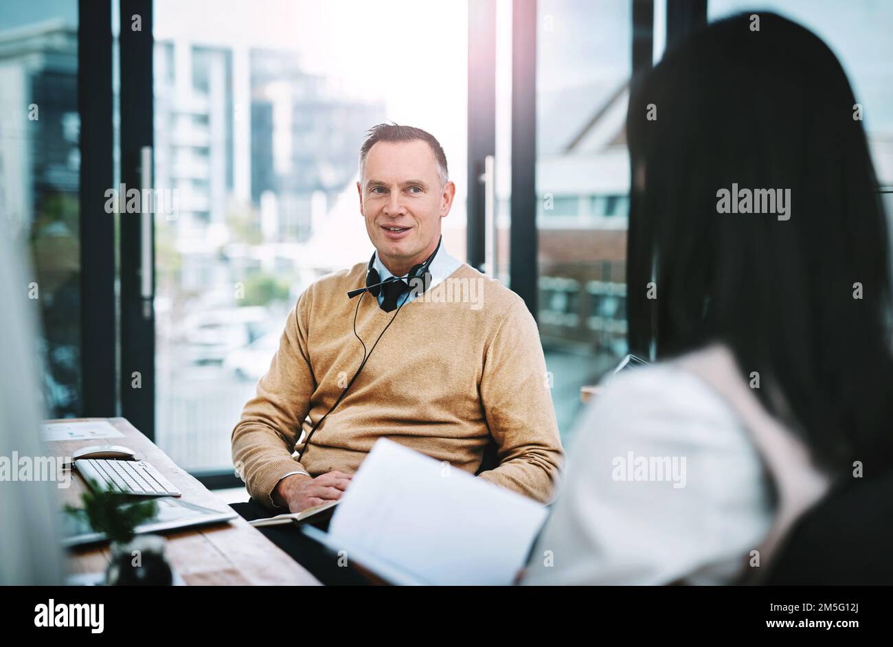 Helping each other help the customers. two call center agents talking ...