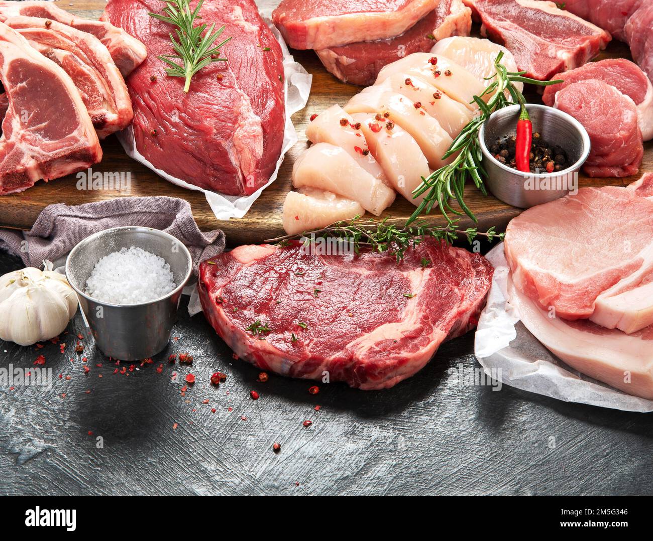 Different types of raw meat - beef, pork, lamb, chicken on dark ...