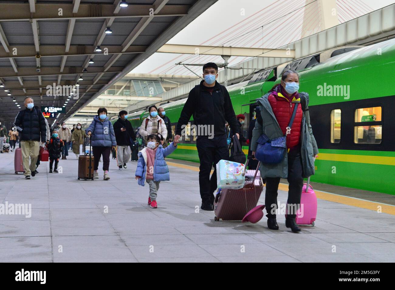Passengers walk past a C57 high-speed train at the Chengdu South ...