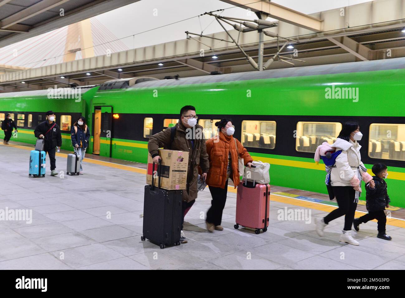Passengers walk past a C57 high-speed train at the Chengdu South ...