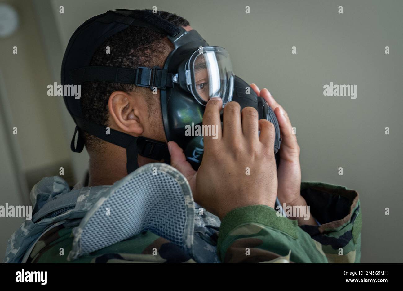 An Airman ensures his gas mask fits properly during a deployment ...