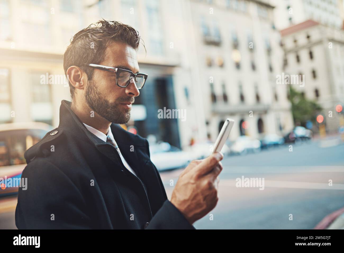 Staying in touch every step of the way. a stylish man using his phone ...
