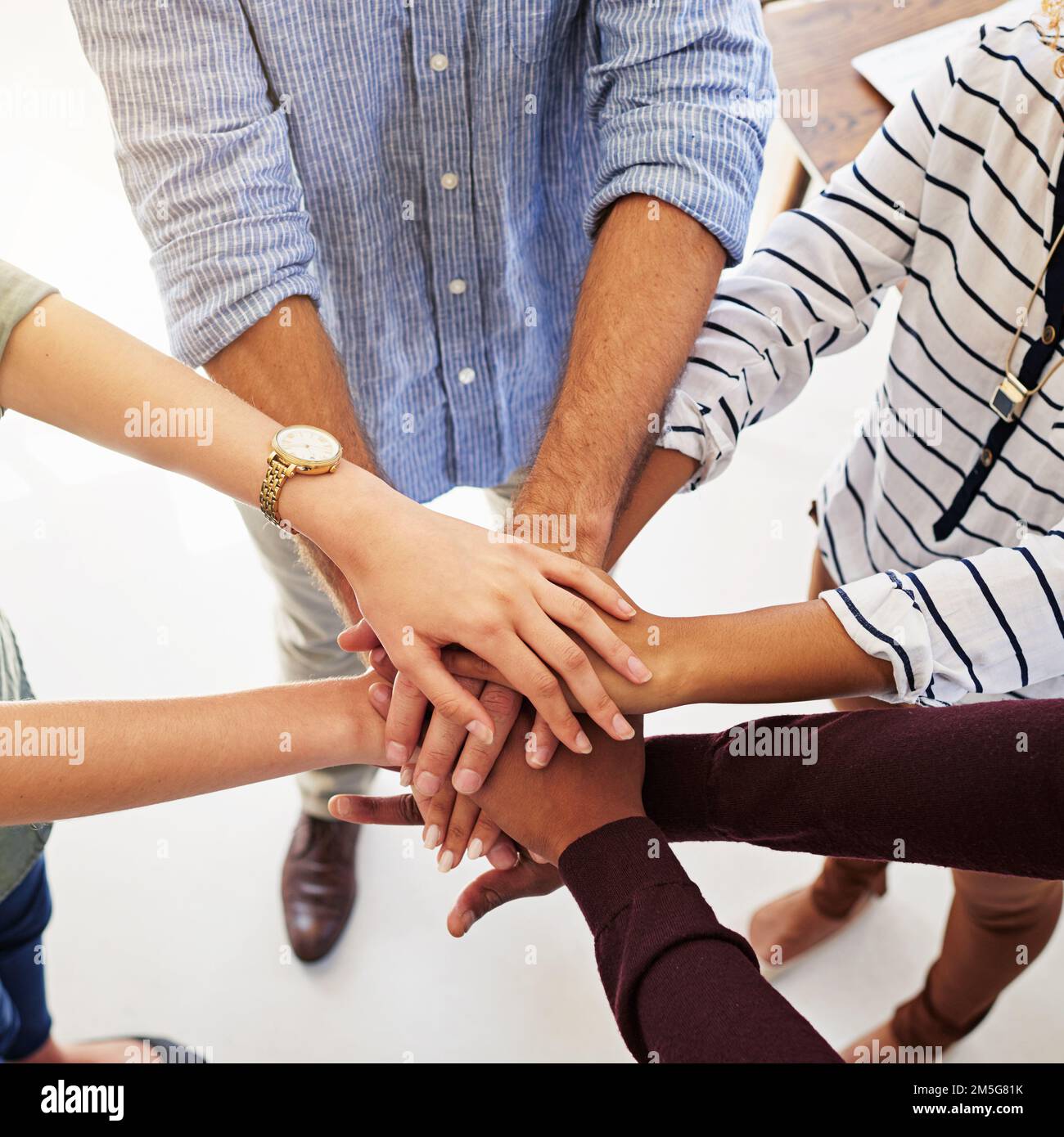 Going all in. a group of colleagues joining their hands in unity Stock ...