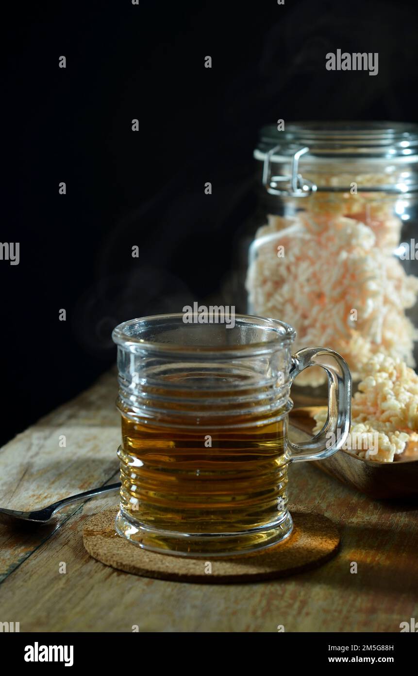 A Cup of freshly tea,escaping steam,warm soft light, darker background ...