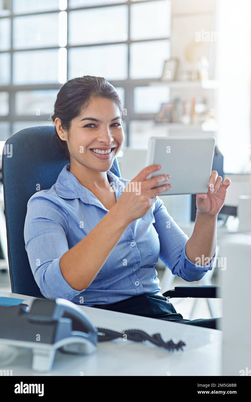 Managing my work tasks with modern technology. Portrait of a young ...