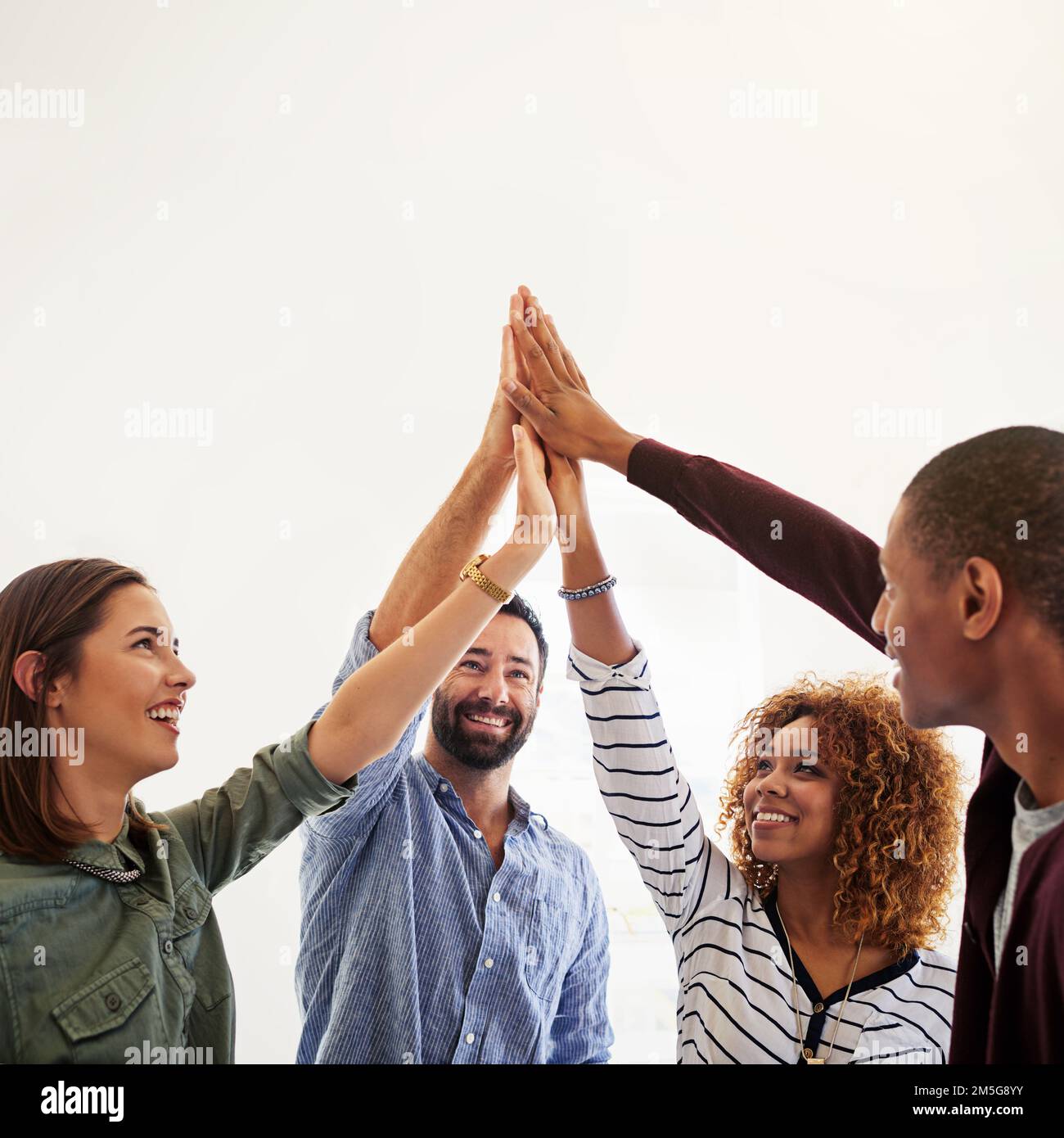 Teamwork for the win. a team of colleagues giving each other a high ...
