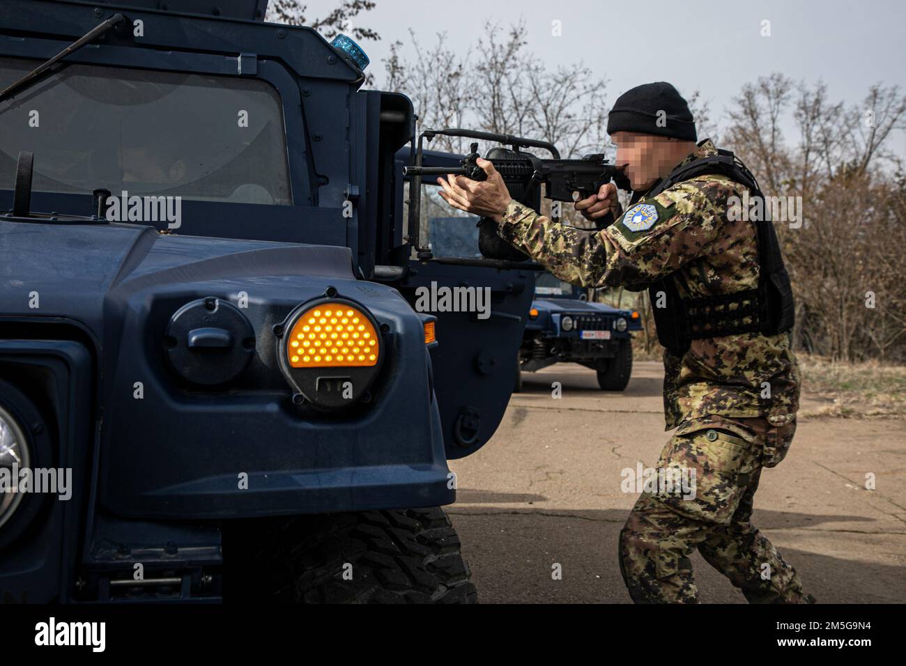A member of Kosovo Special Intervention Unit aims his weapon at a ...