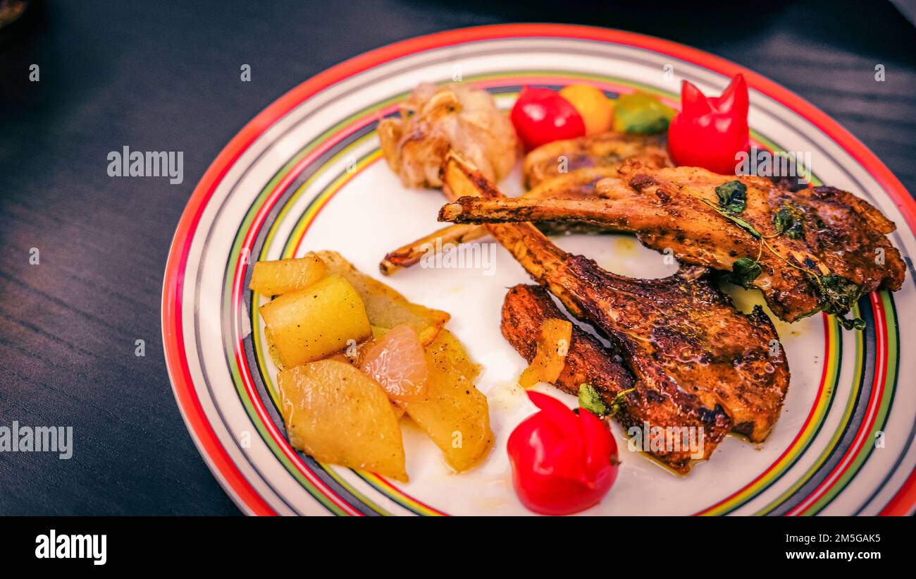 A plate with roast lamb racks with cherries Stock Photo - Alamy
