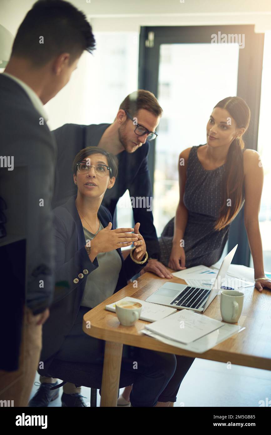 Sharing ideas and information. a group of coworkers discussing ...