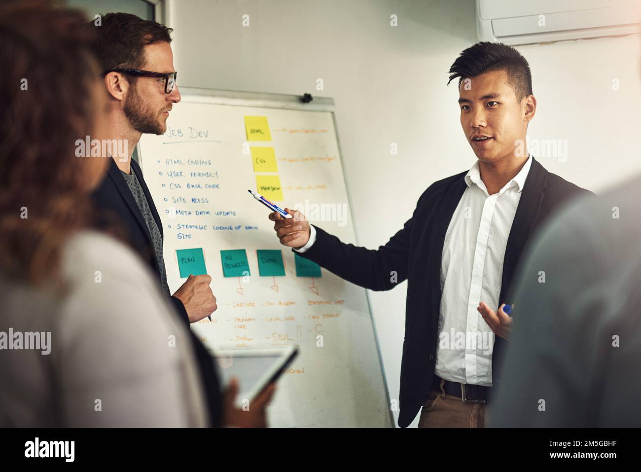 Putting his plan into action. a young man giving a presentation to ...