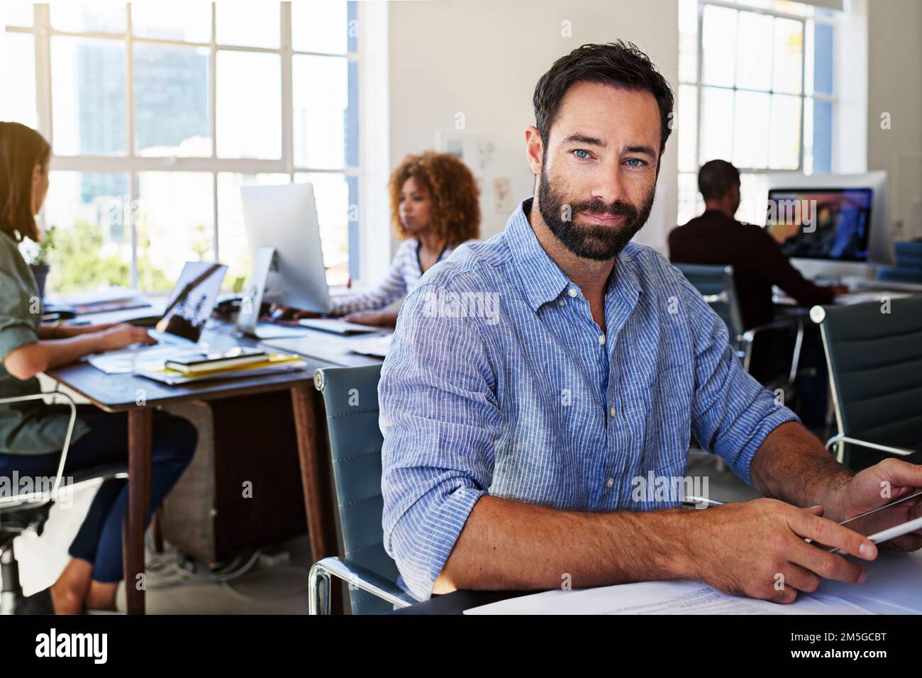 Reaching my work goals with modern technology. Portrait of a man using ...