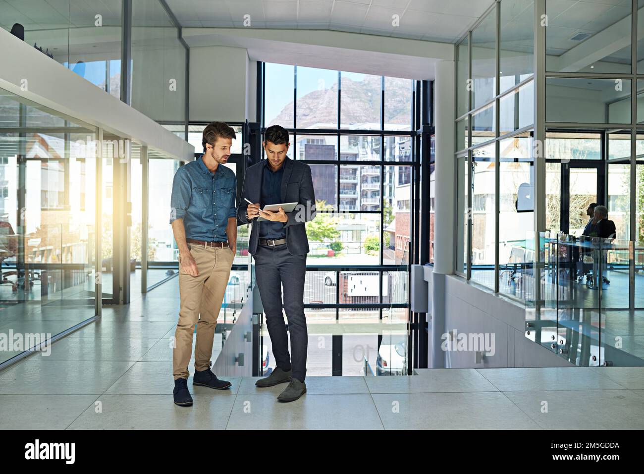 Talking digital strategy. two colleagues talking together over a ...