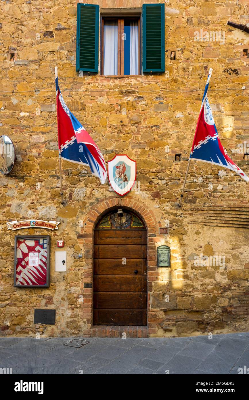 Gate of an old building with flags and advertising poster, Montisi ...