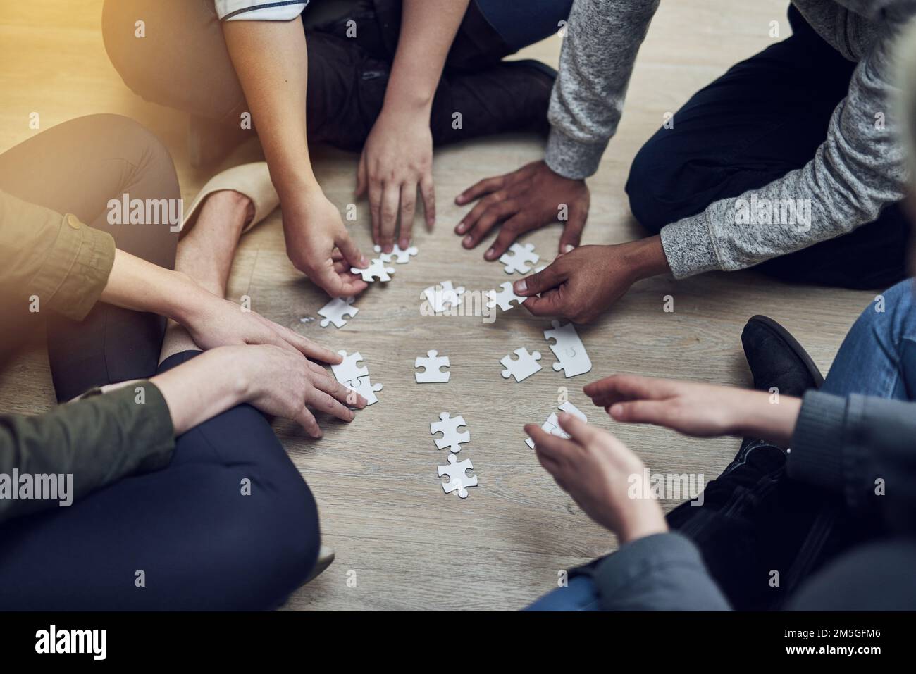 Accomplishing the task as a team. a group of people building a puzzle ...