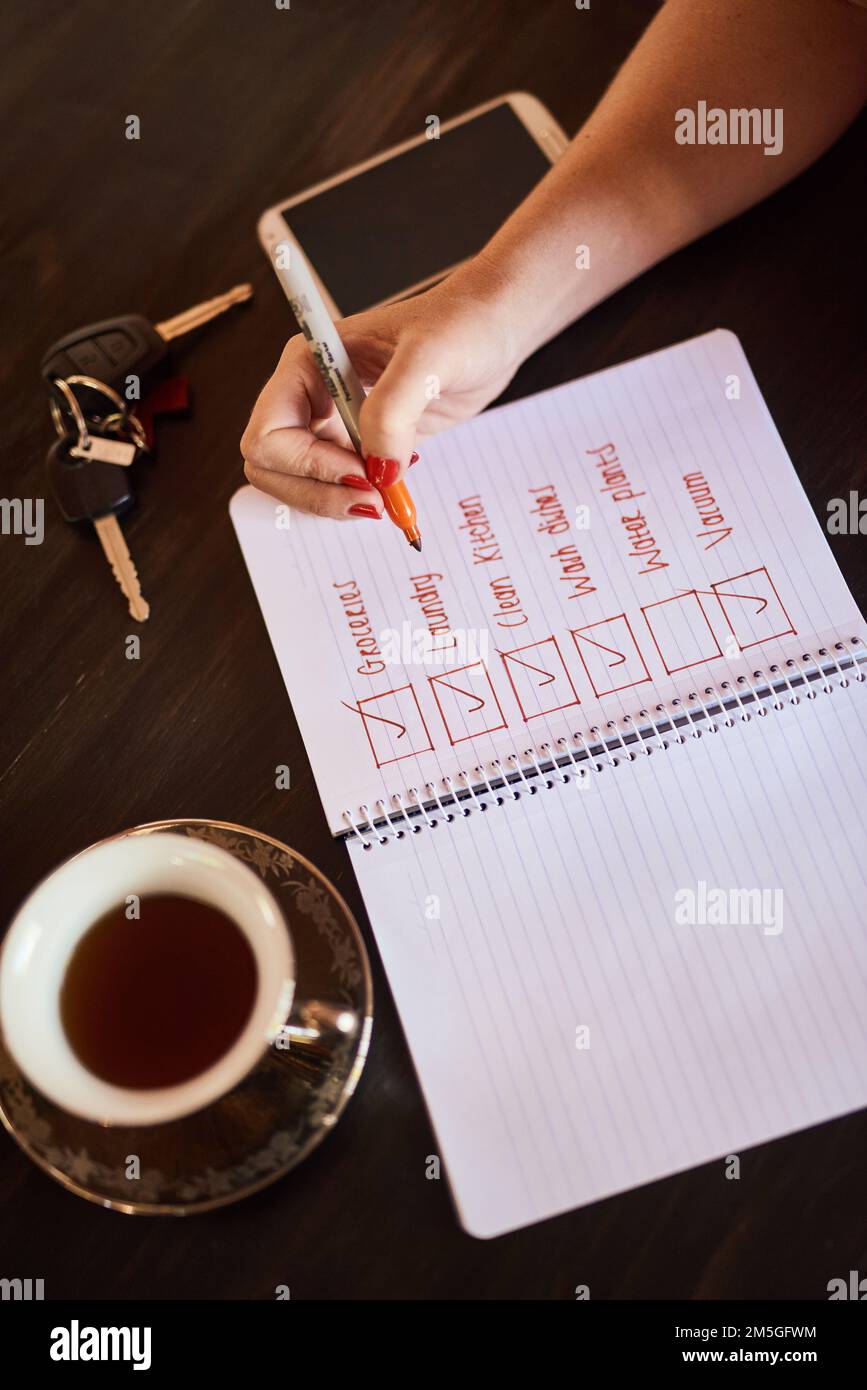 One more task left...High angle shot of a woman ticking chores off of ...