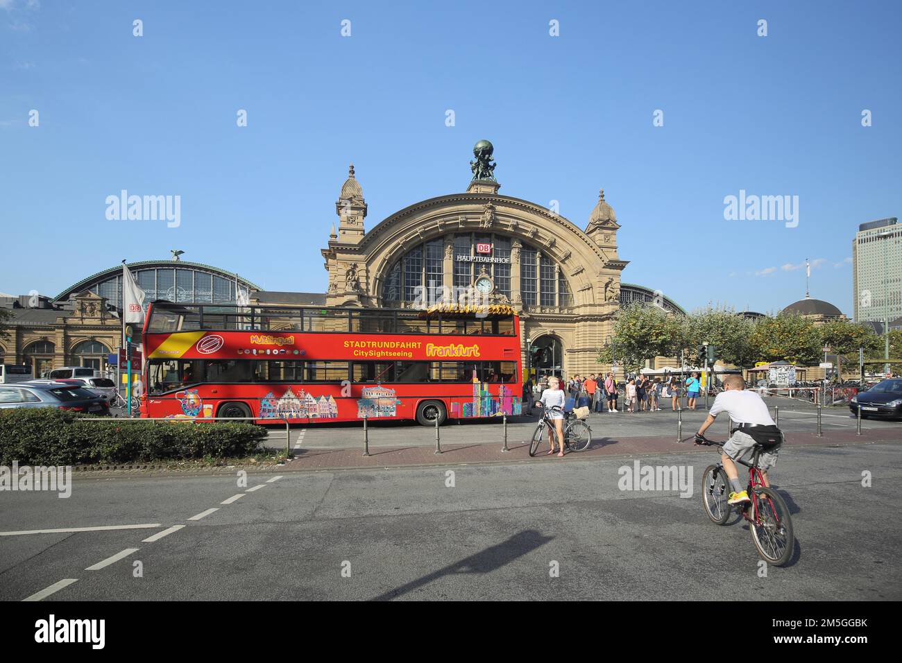 Building of the main station with cyclist and city tour sightseeing bus ...