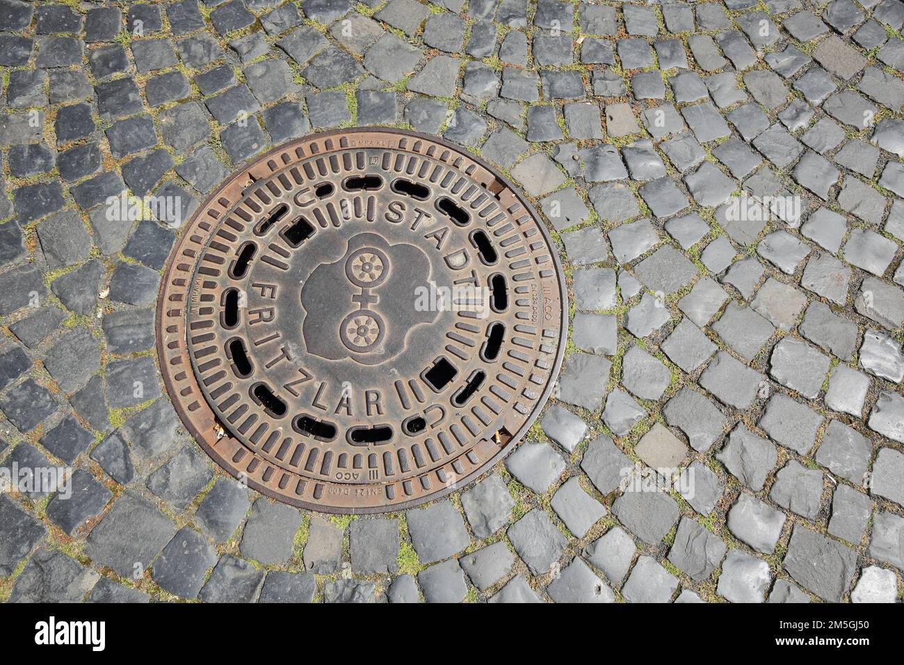 Manhole cover with city coat of arms and inscription, city, paving ...