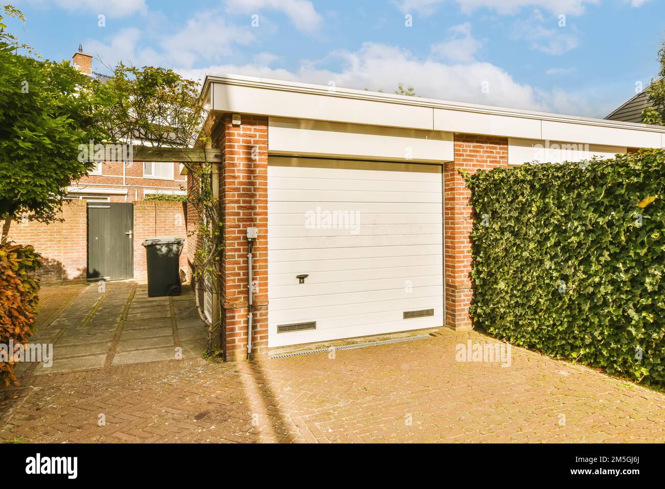a brick house with a white garage door on the right side and green ...