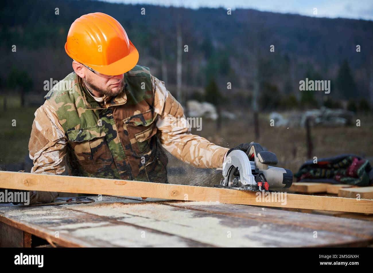 Carpenter using circular saw for cutting wooden joist. Man worker ...