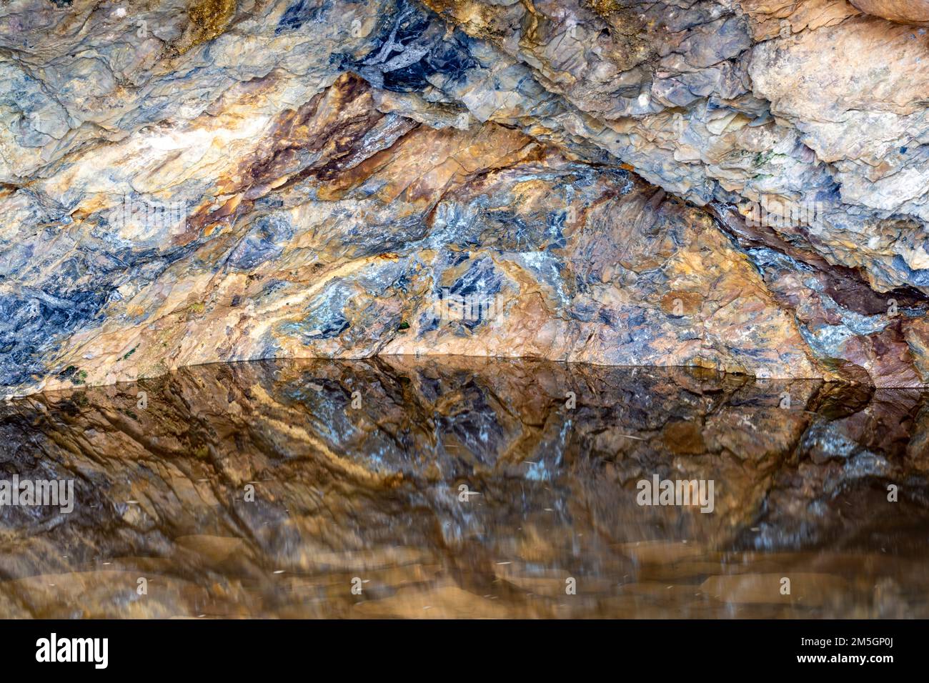 Reflections of red copper ore in pool in a cave Stock Photo - Alamy