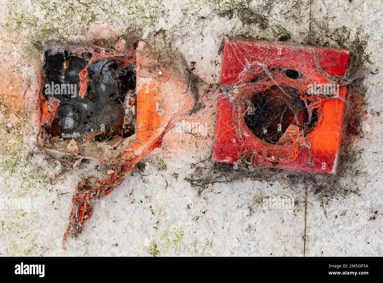 Vandalised fire alarm button and wall socket in abandoned building ...