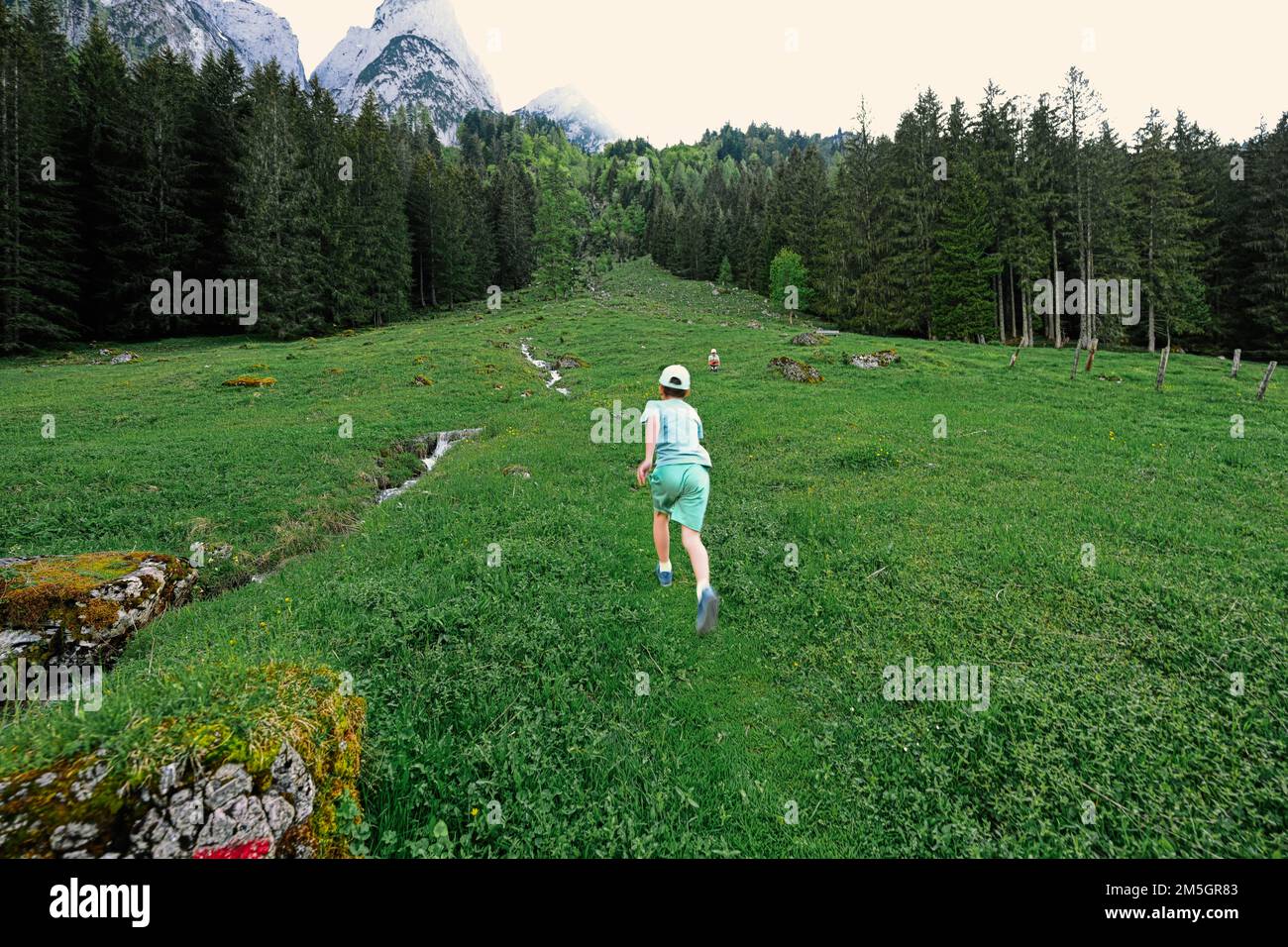Boy walking near mountain clean water source at Vorderer Gosausee ...