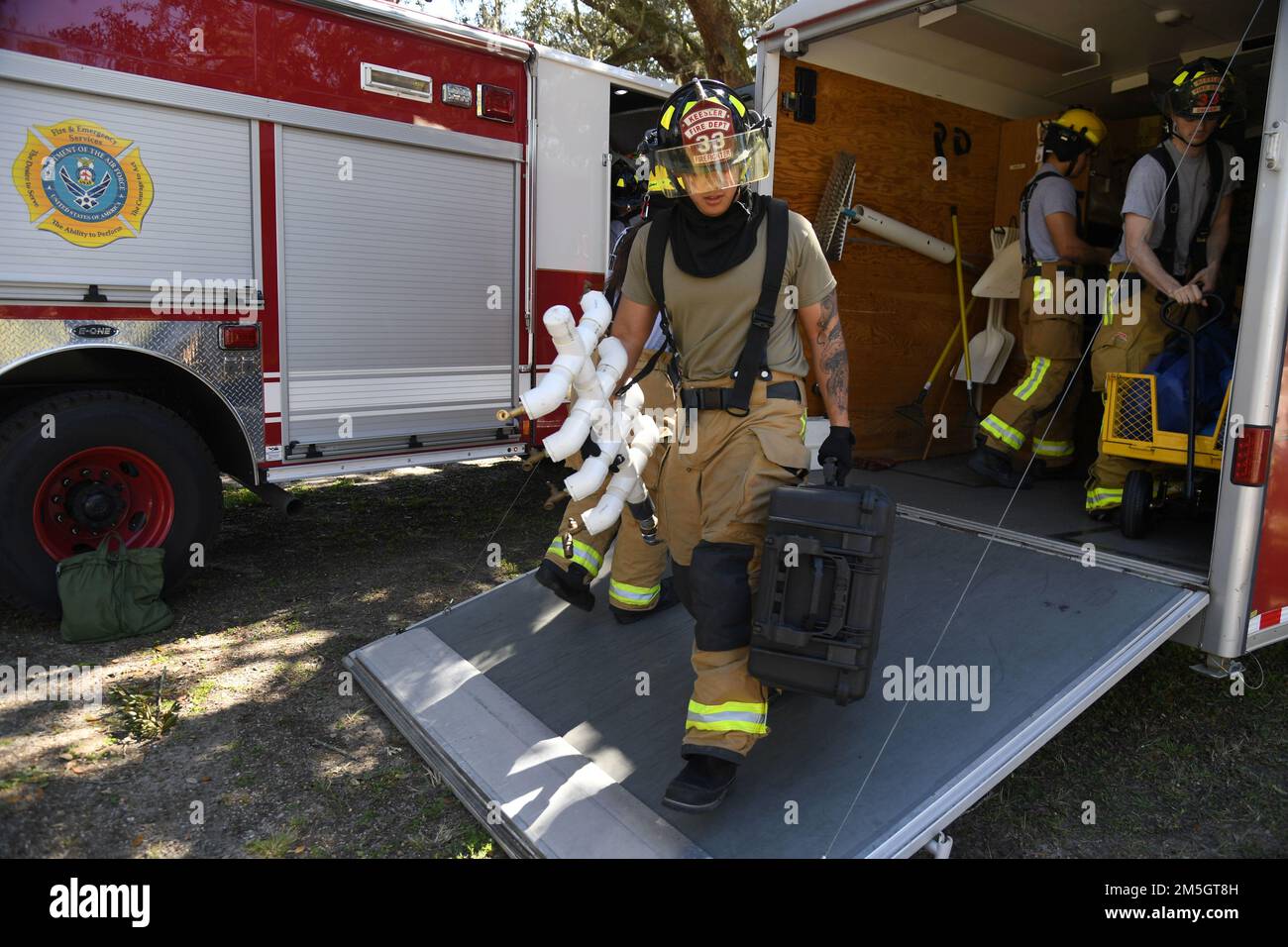 Members of the Keesler Fire Department gather equipment to set up a ...