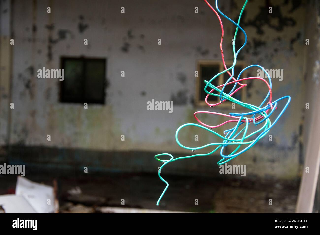 Dangerous bad wiring which hangs on the ceiling from an old house Stock ...