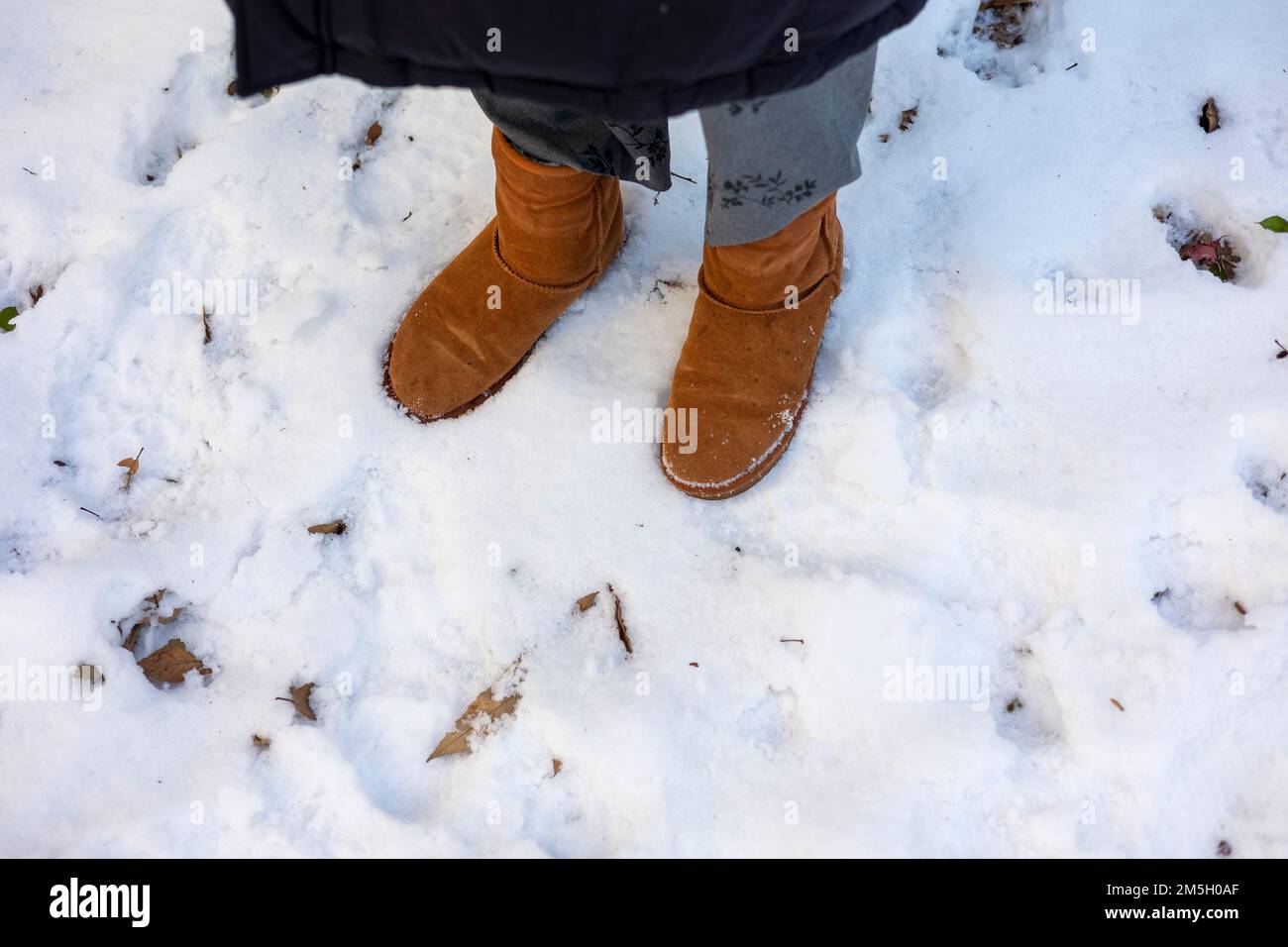 Woman's boots on the snow beside footprints Stock Photo - Alamy