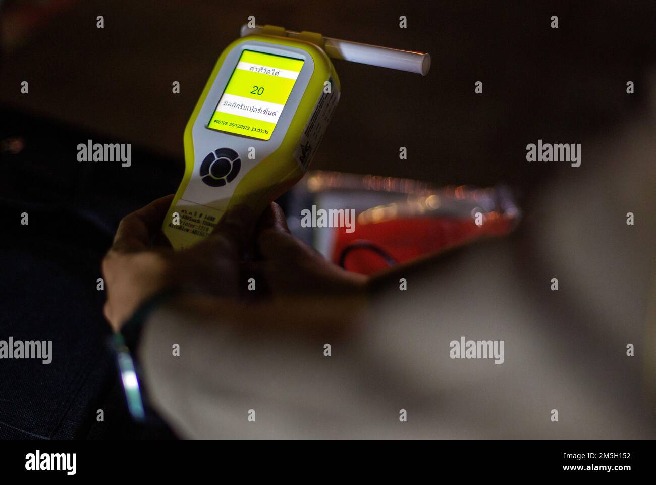 A Thai police officer shows the breathalyzer with a normal alcohol ...