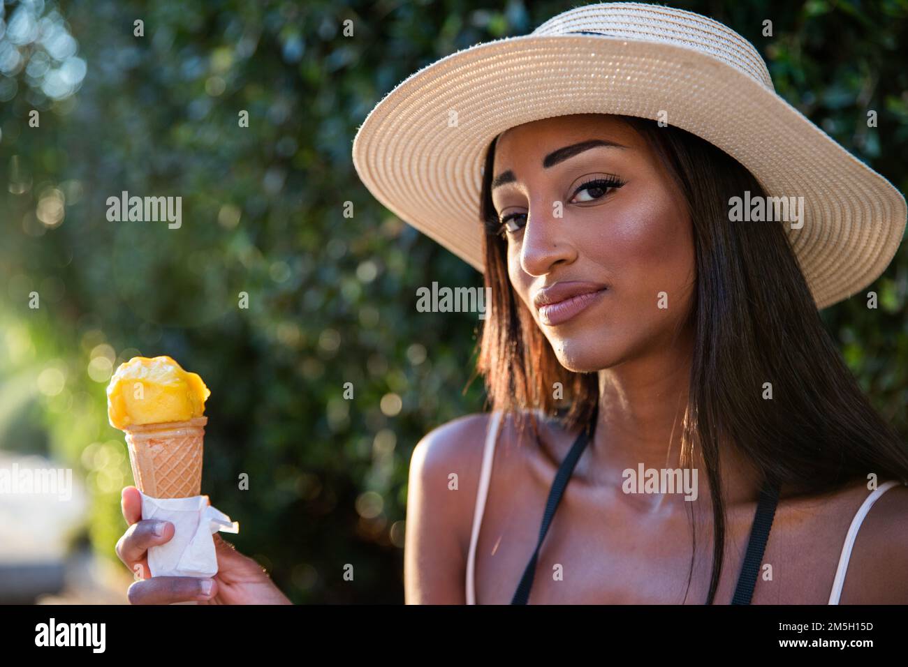 Portrait of an attractive African girl eating an ice cream in the ...