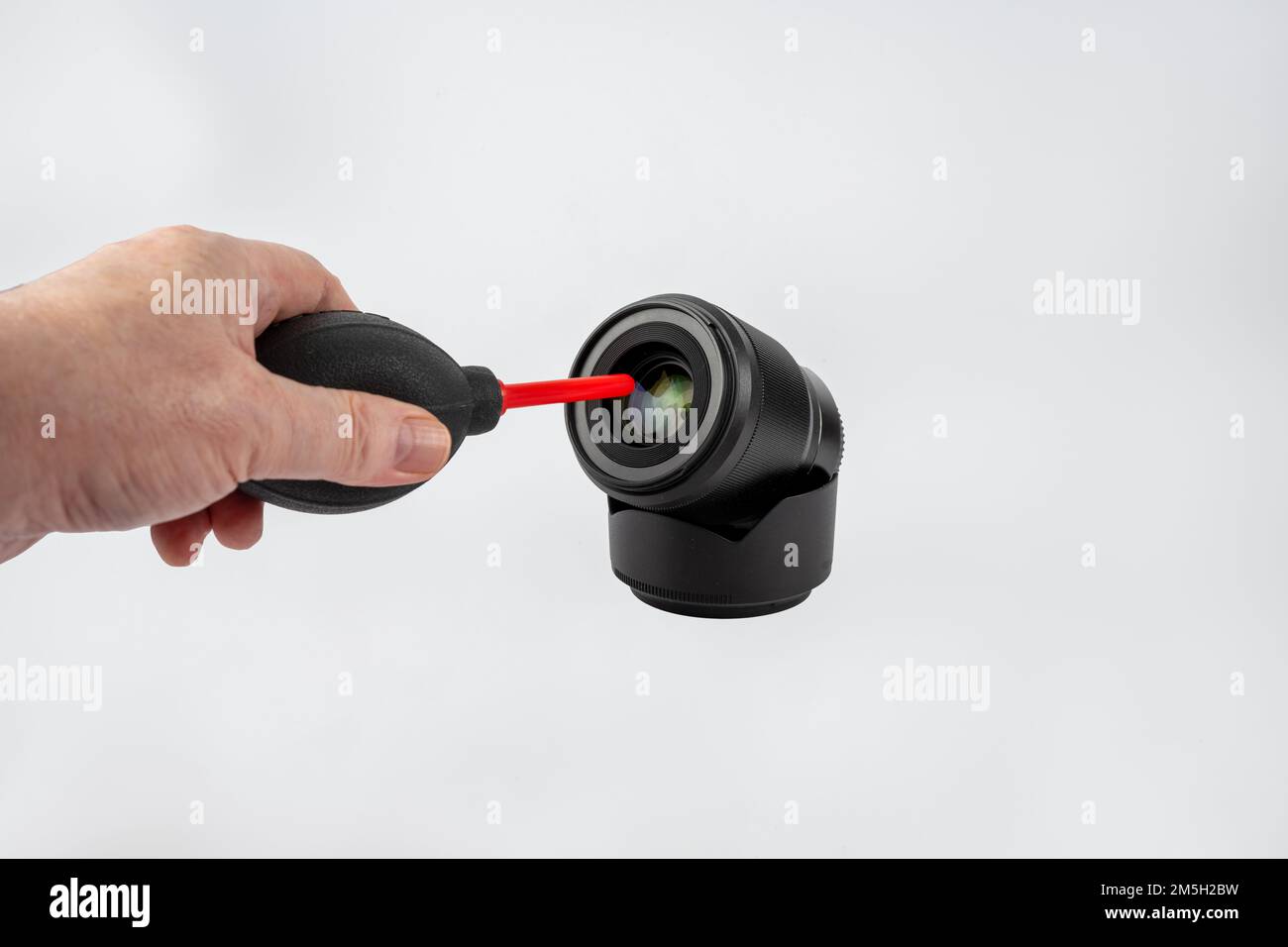 photographer blowing the dust particles off the front element of the ...