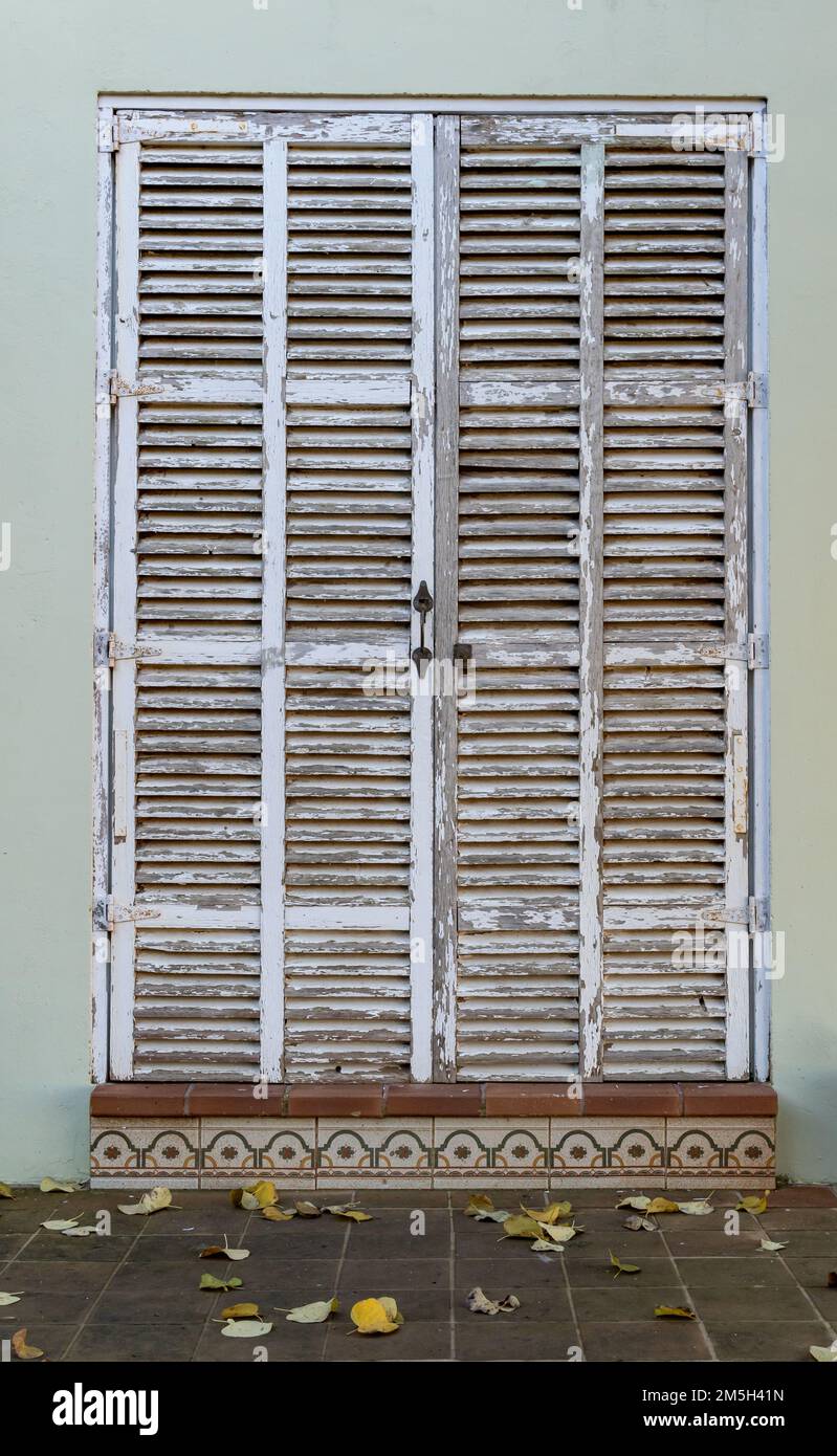 White Mallorcan shutter door closed with a padlock. Conceptual image of ...