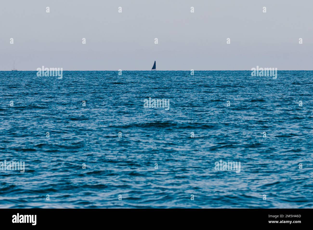 Boat sailing on the horizon Stock Photo - Alamy