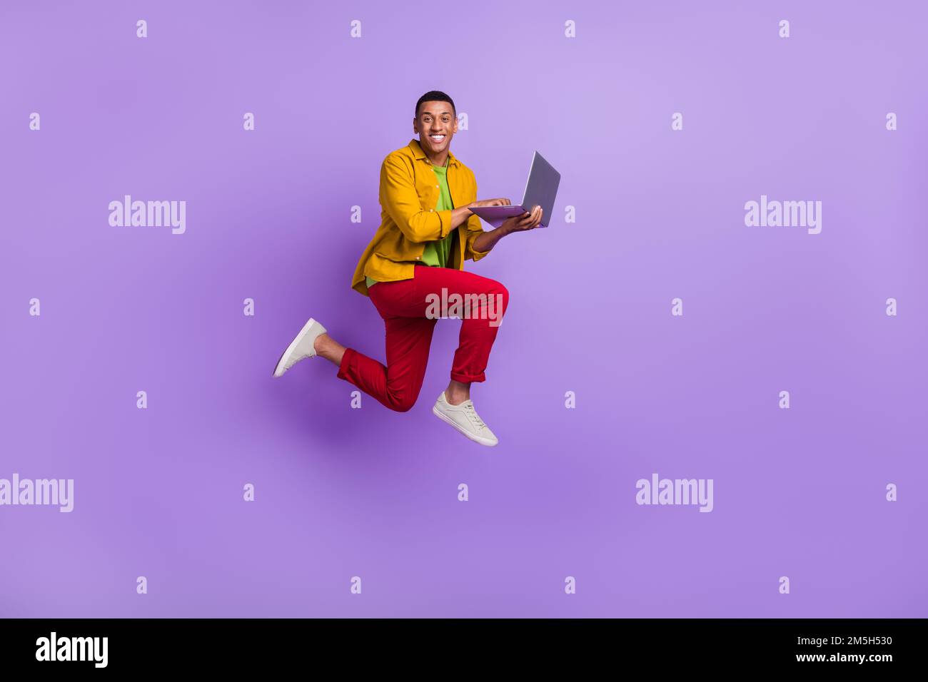 Full length profile photo of excited man jumping rush fast use netbook ...